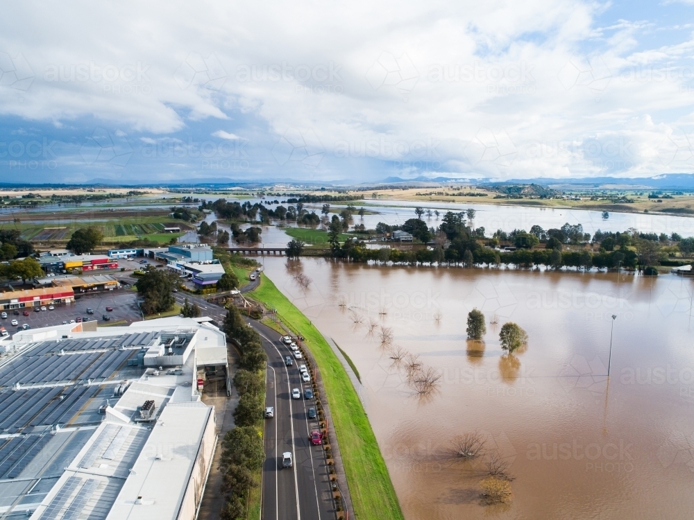 Image of floodwaters covering riverside park beside township rising up ...
