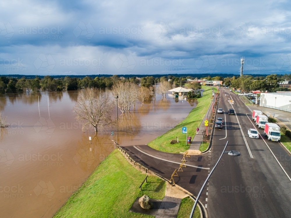Image of floodwaters covering riverside park beside township rising up ...