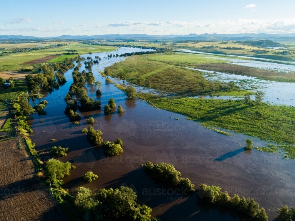 Image of Floodwaters of river rising up and flooding over farmland ...