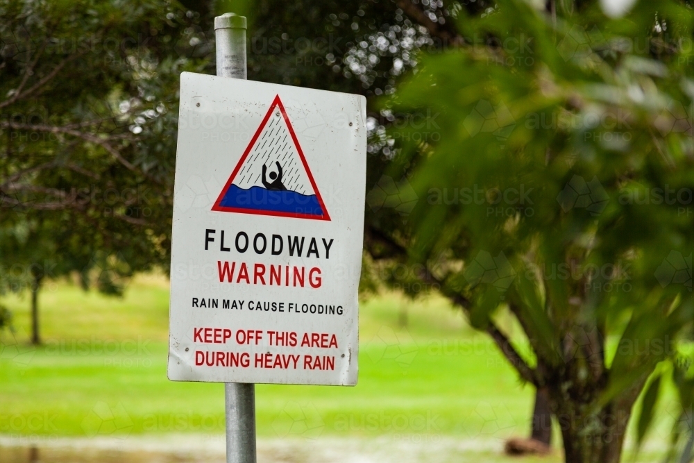 Image of Floodway warning sign with rising water behind on rainy day ...