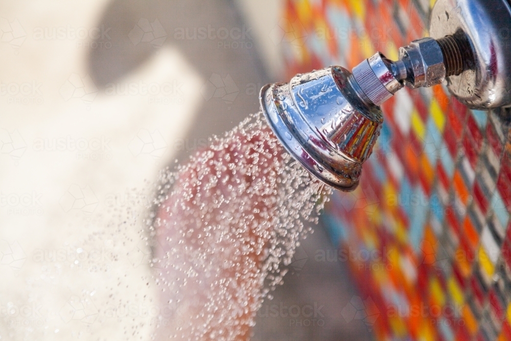 Image of Foot and shower rinse head beside beach for washing off sand ...