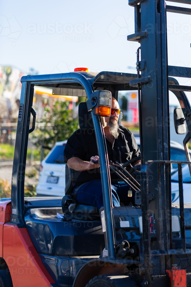 Image of forklift operator driving forklift outside in industrial area ...