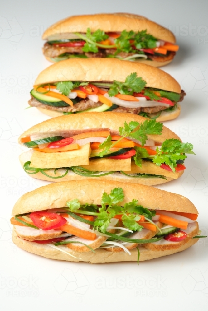 Image of Four banh mi lined up on blank background - Austockphoto