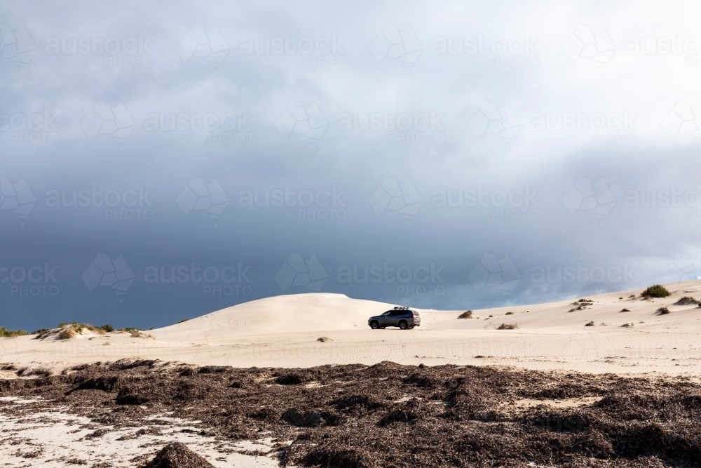 Image of four wheel drive driving through sand dunes - Austockphoto