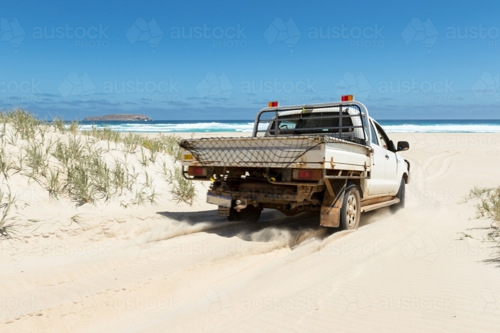 Image of Four wheel drive ute driving onto beach - Austockphoto