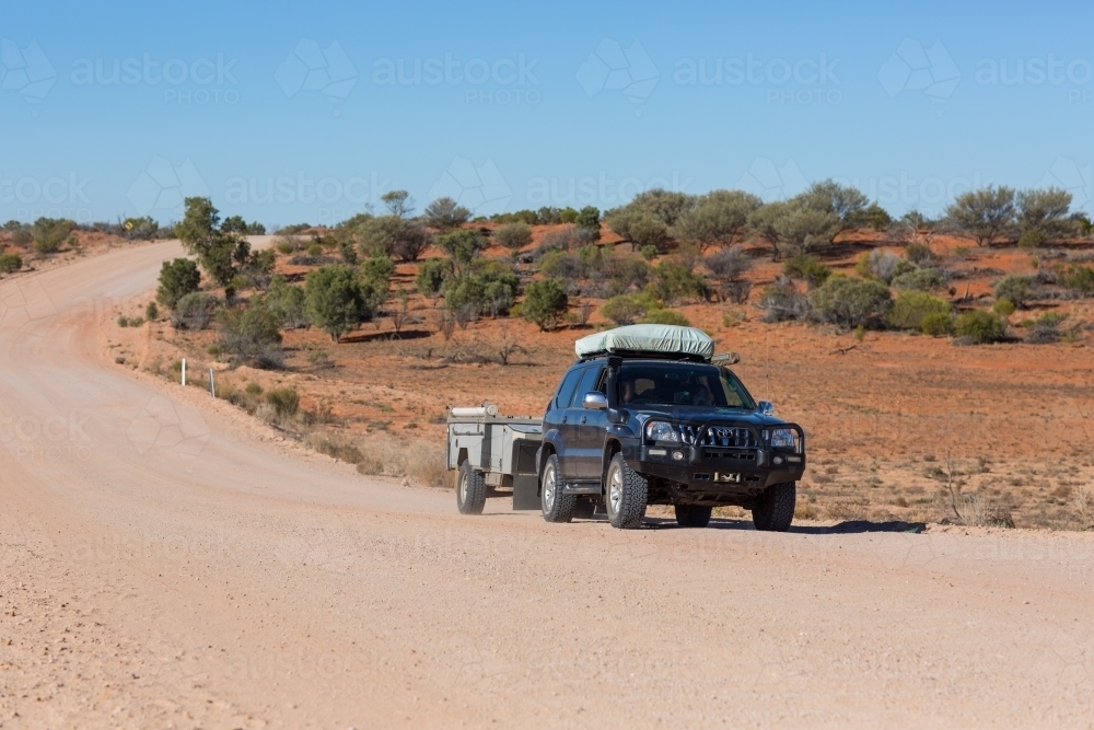 Image of Four wheel drive vehicle towing camper trailer in the outback ...