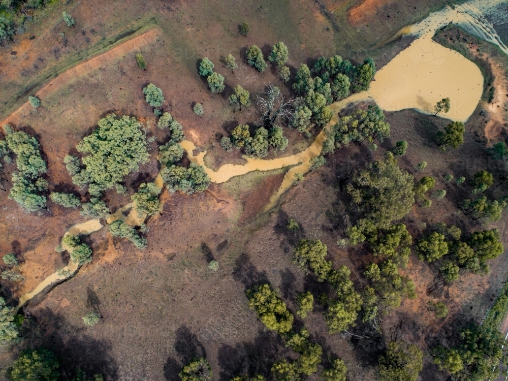 Image of Full creek and overflowing dam in rural paddock - Austockphoto