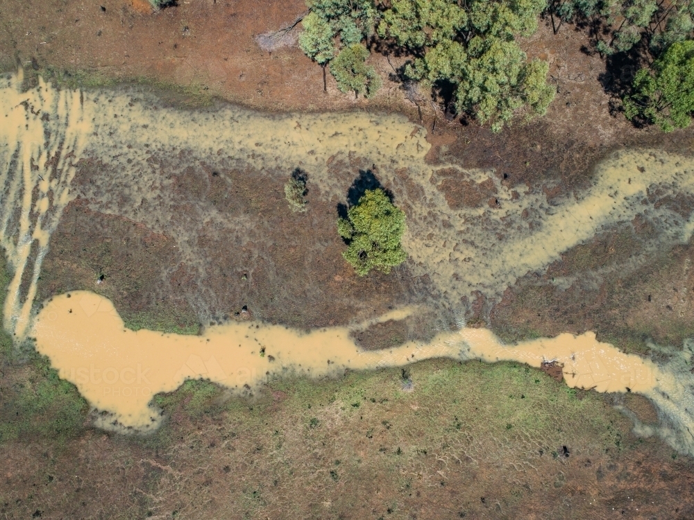 Image of Full creek and overflowing dam in rural paddock - Austockphoto
