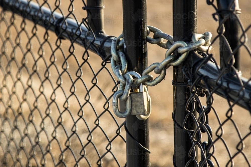 Image of Gates of an empty lot chained shut - Austockphoto