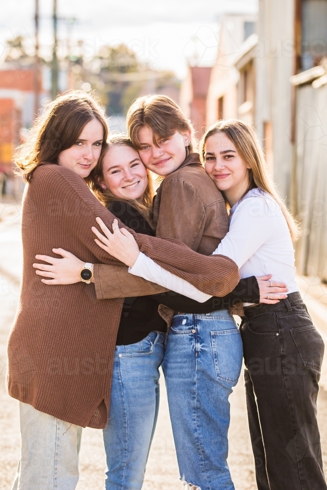 Image of Girl friends standing cuddling and smiling - Austockphoto