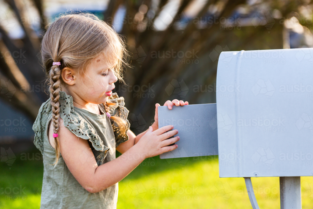 Image of Girl opening mailbox in front yard checking for letters ...