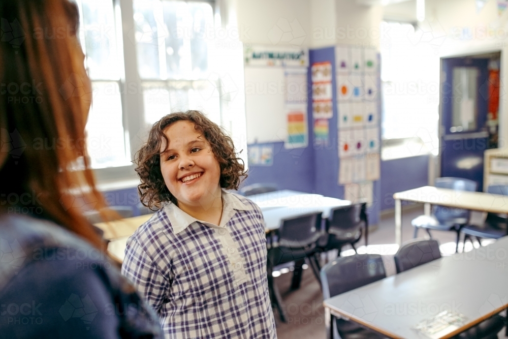 Image of Girl primary school student smiling up at her teacher in the ...