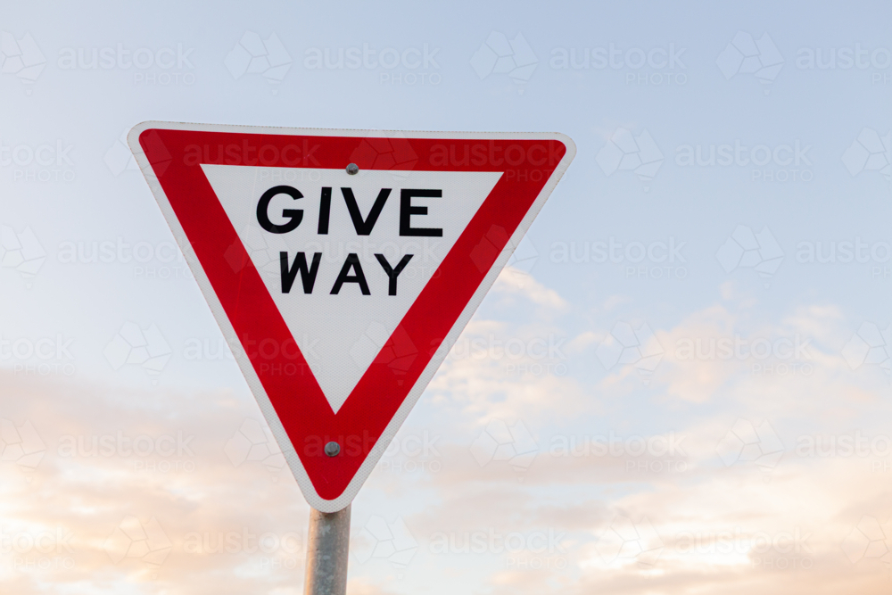 Image of Give way sign on post with soft pastel sky backdrop at dusk ...