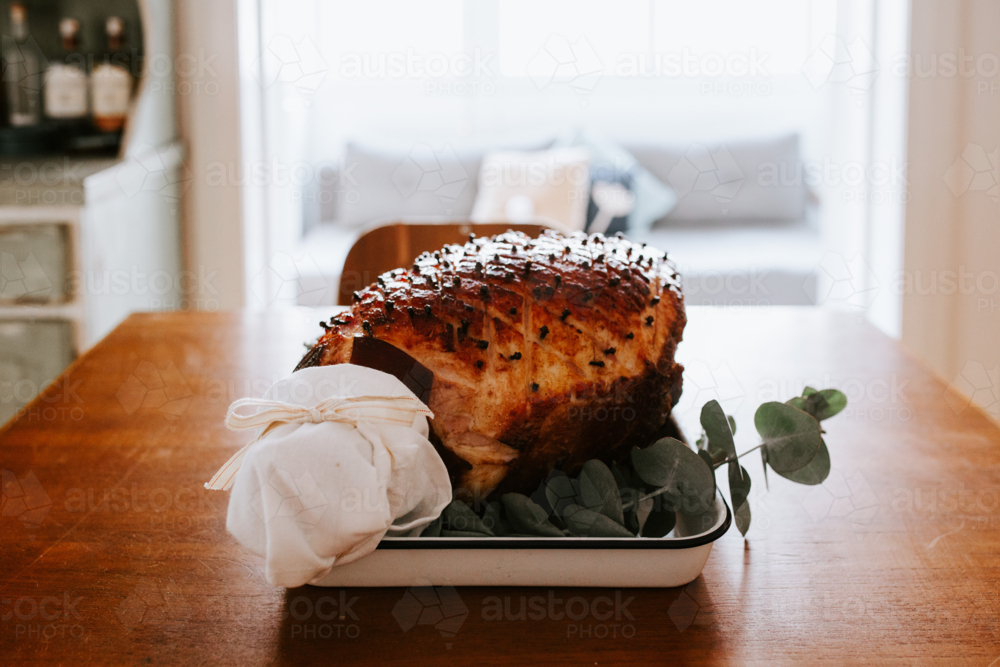 Image of Glazed and roasted holiday ham with cloves sitting on the ...
