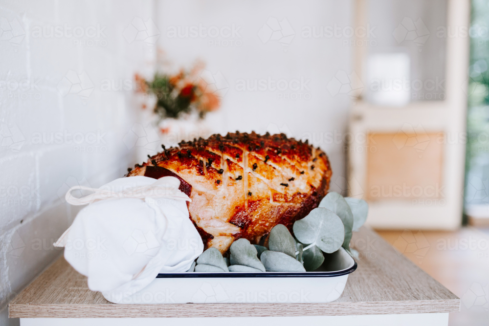 Image of Glazed and roasted holiday ham with cloves sitting on the ...