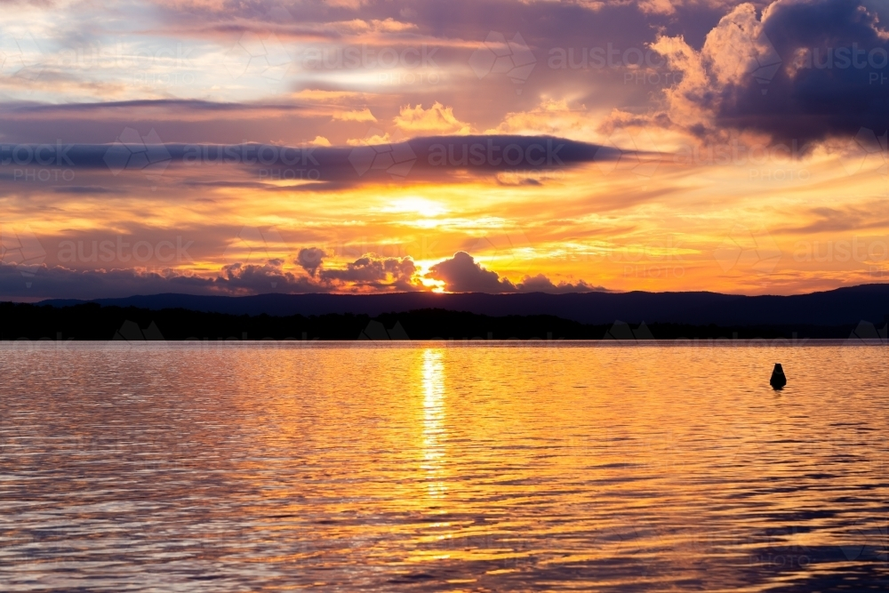 Image of Golden purple sunset light over lake water with buoy on ...