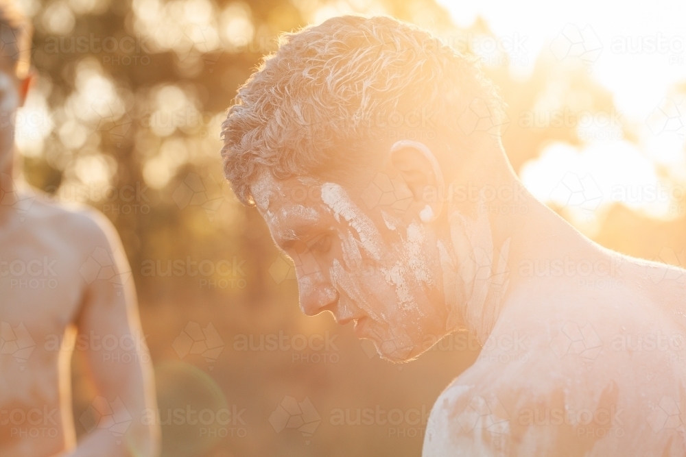 Image of Golden sunlight rays over profile of teenaged First Nations ...