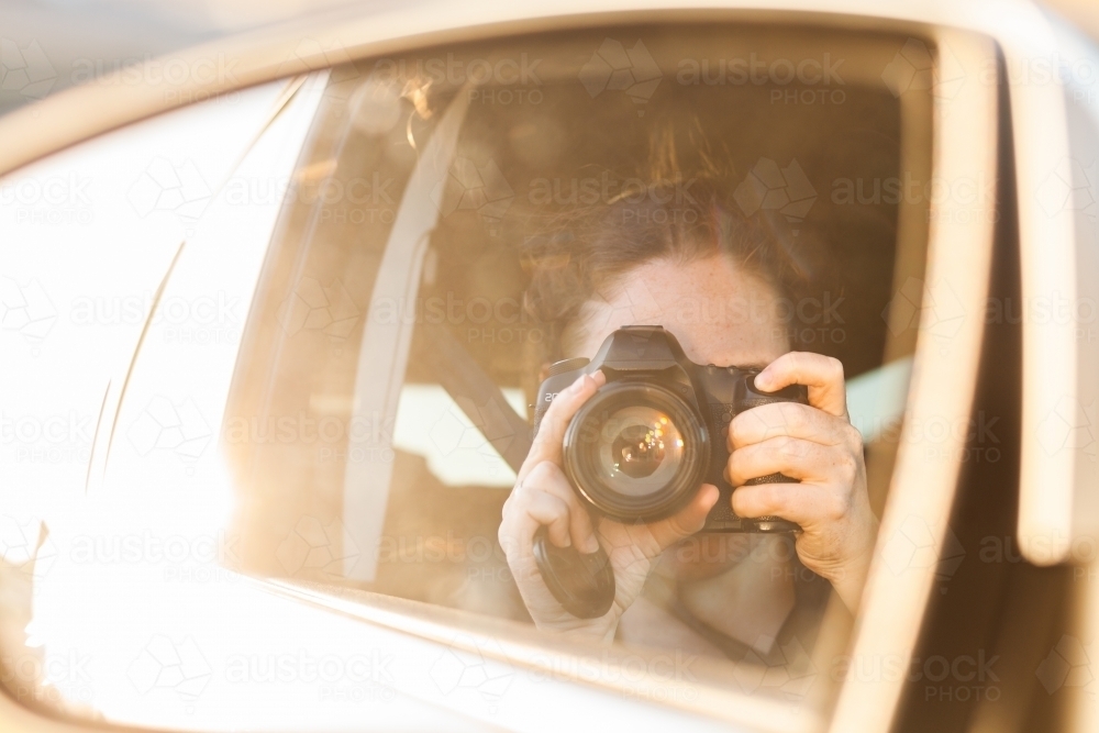 Image of Golden sunlit reflection of photographer on road trip in car ...