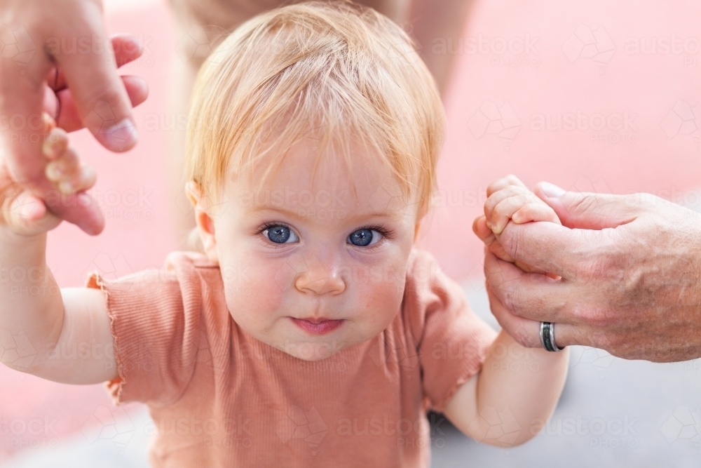 Image of Grandfathers hand holding baby's hand helping baby to walk ...