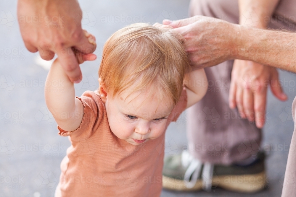 Image of Grandfathers hand holding baby's hand helping baby to walk ...