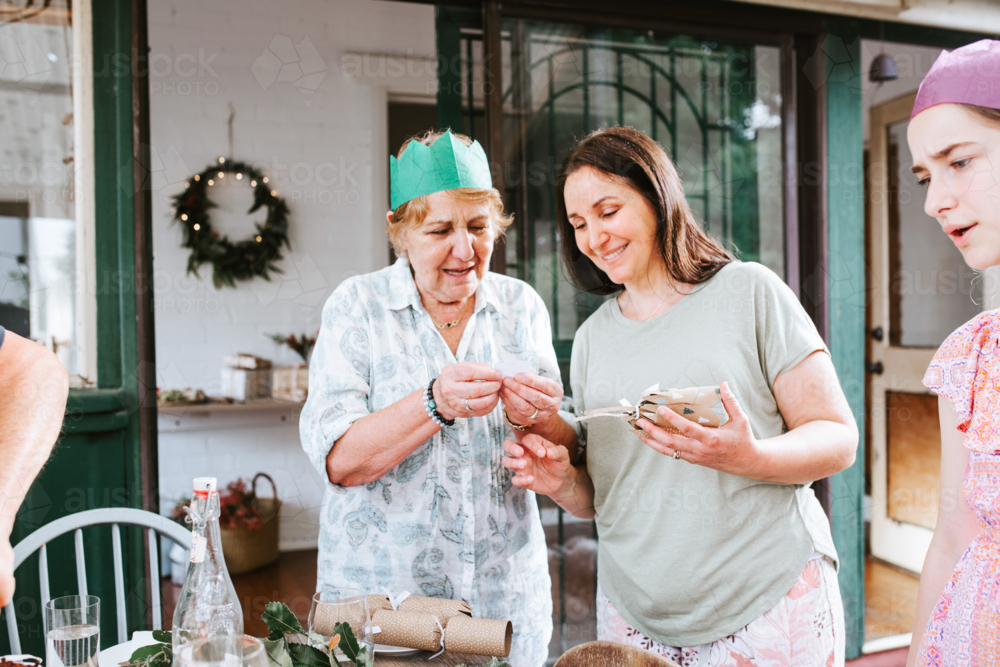 Image of Grandma opening Christmas crackers during Christmas dinner on ...