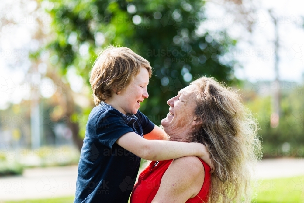 Image of Grandmother carrying her grandson, laughing together outside ...
