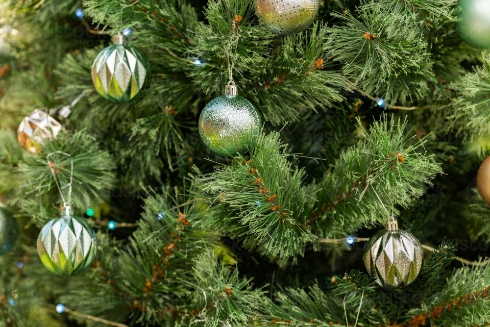Image of Green and gold christmas baubles and string lights in tree ...