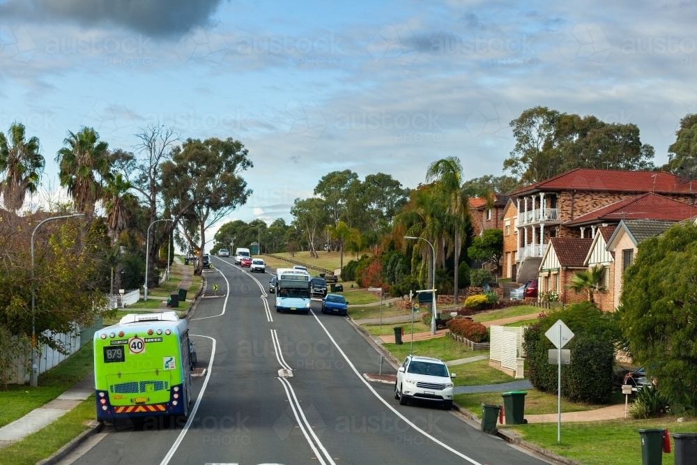 Image of Green bus pulling over to the side of the road and blue bus ...
