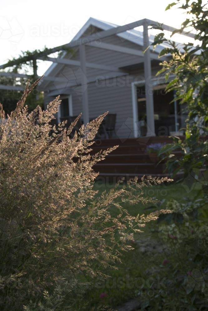 Image of Grey weatherboard house with wooden deck and garden in ...