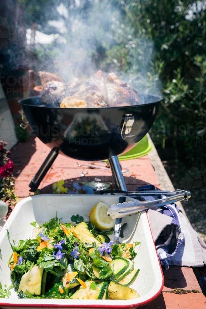 Image of Grilling chicken and making salad for lunch on a summers day ...