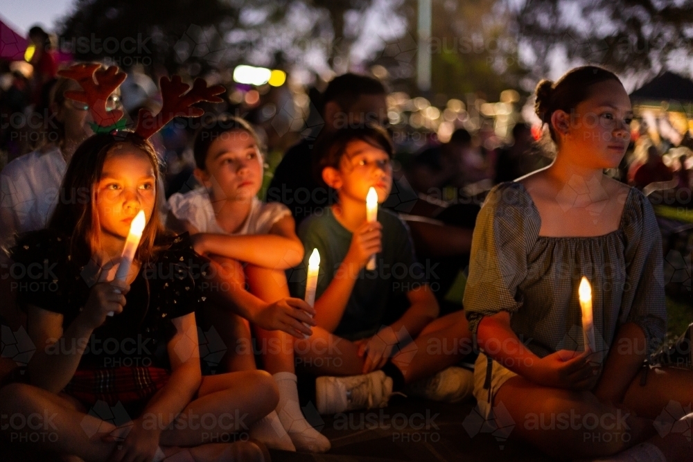 Image of group of children at carols by candlelight with artificial ...