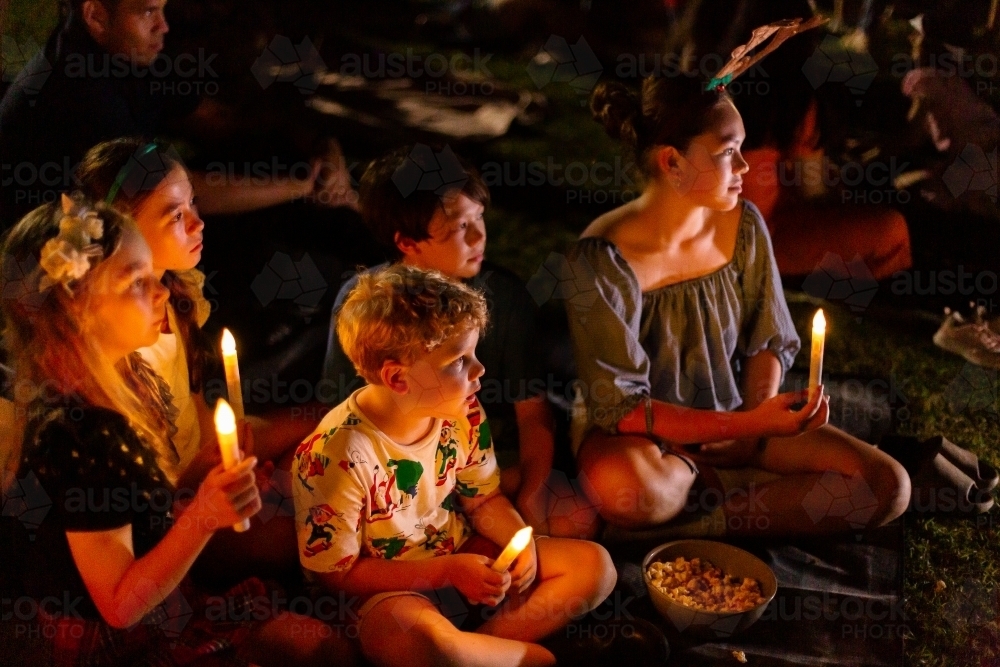 Image of group of children holding candles at a carols event - Austockphoto
