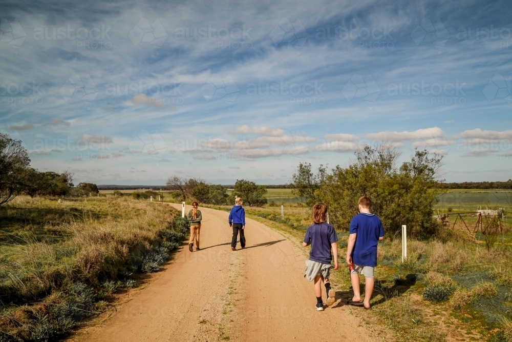 Image of Group of children walking together along remote country road ...