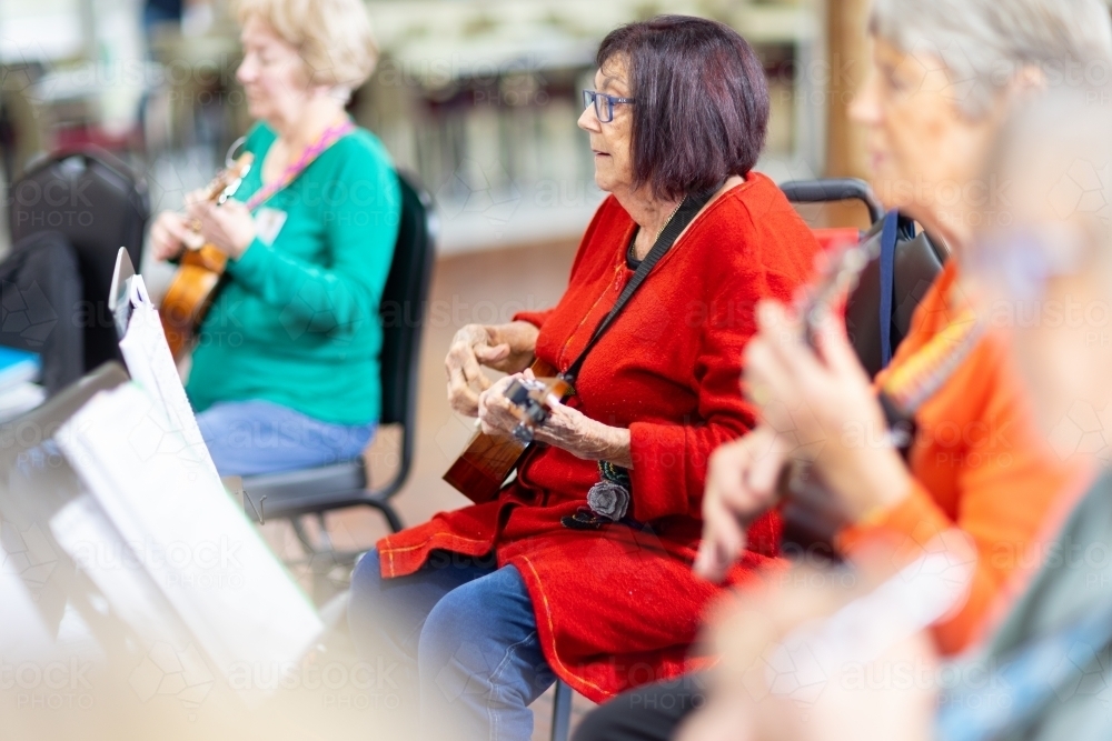 Image of group of elderly women playing ukulele together - Austockphoto