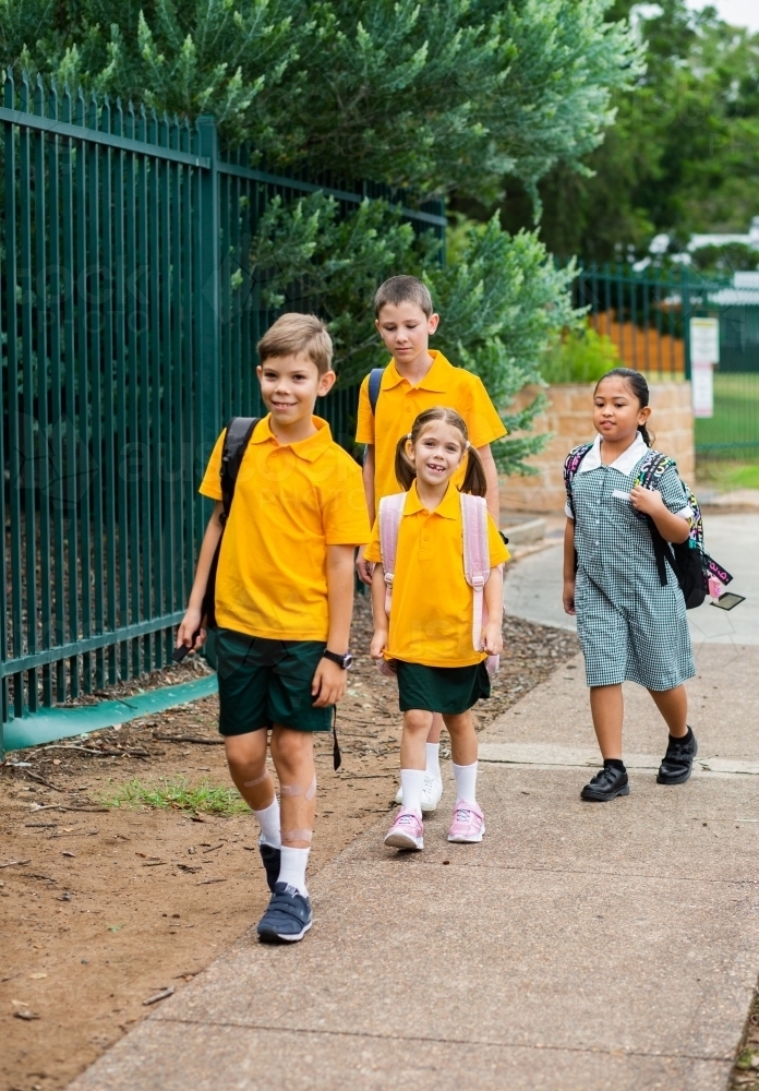 Image of Group of happy kids walking to school together - Austockphoto