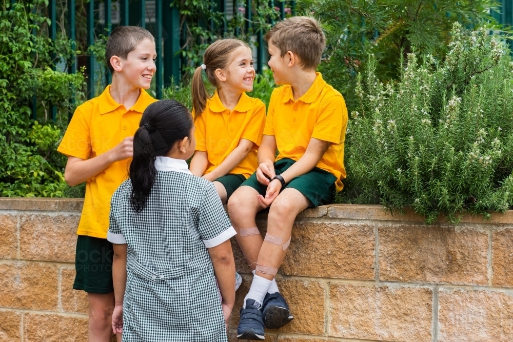 Image of Group of school kids chatting together outside - Austockphoto