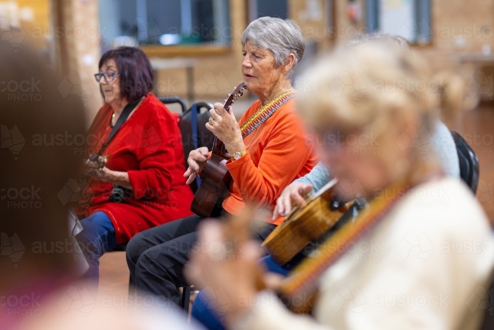 Image of group of senior women playing ukulele - Austockphoto