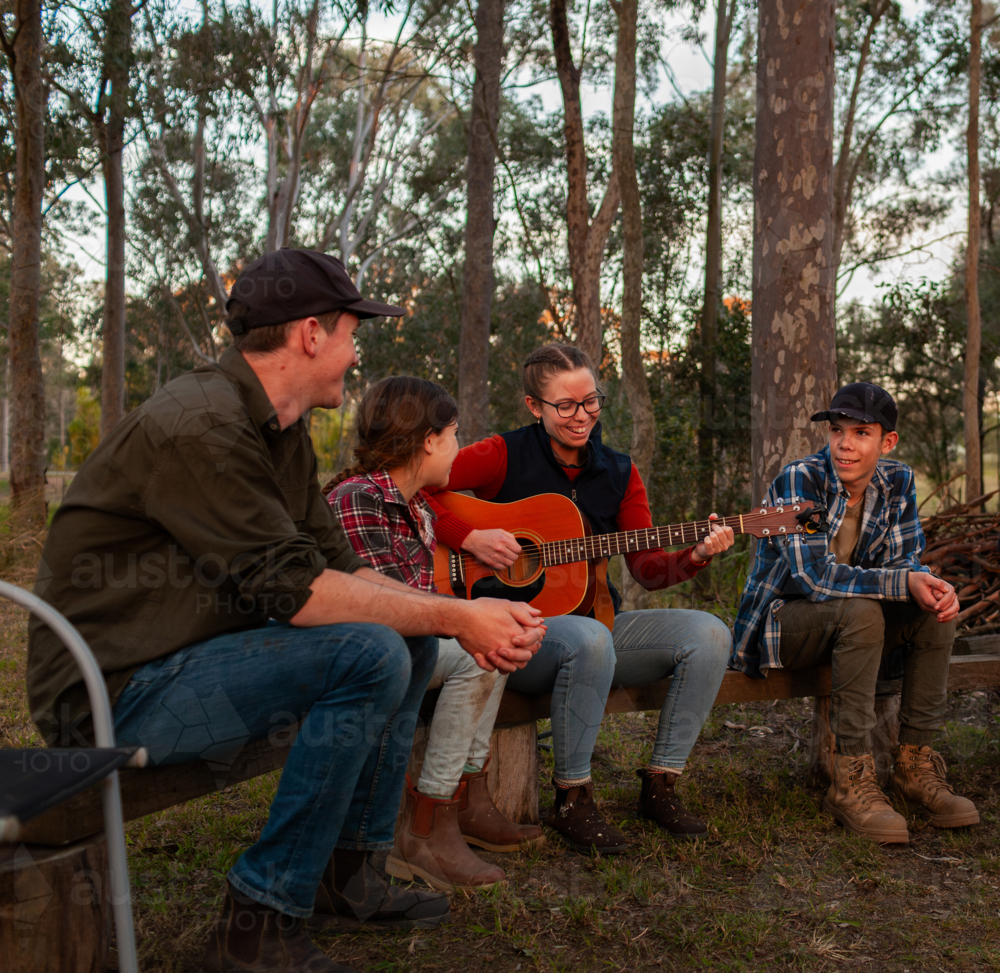 Image of group of siblings sitting around singing together at ...