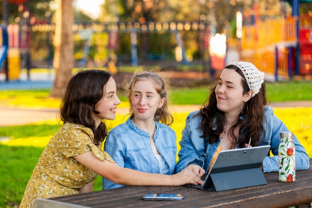 Image of Group of teenaged friends collaborating on project together at ...