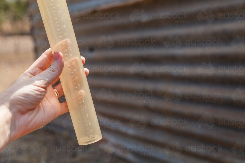 Image of Hand holding empty rain gauge drought concept - Austockphoto