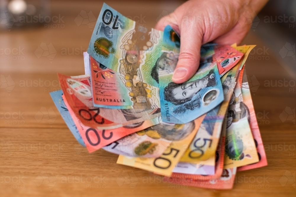 Image of hand holding fanned out Australian notes - Austockphoto