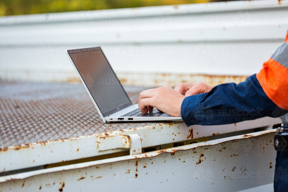 Image of hands of trainee tradie apprentice working on laptop in back ...