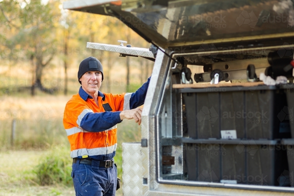 Image of Handyman getting tools from back of tradie ute - Austockphoto