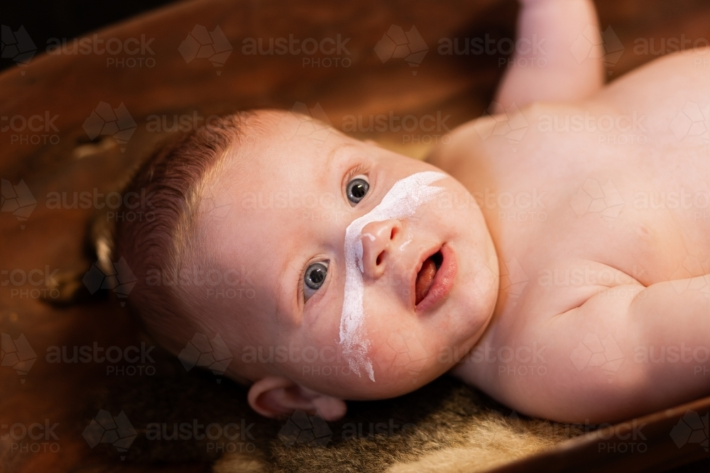Image of Happy Aboriginal baby boy lying on possum skin in coolamon ...