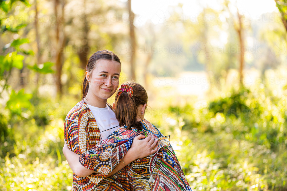 Image of Happy aboriginal sisters hug outside in morning sunshine ...