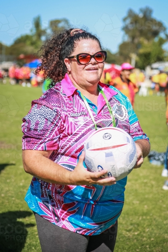 Image of Happy Aboriginal woman with glasses holding netball - Austockphoto