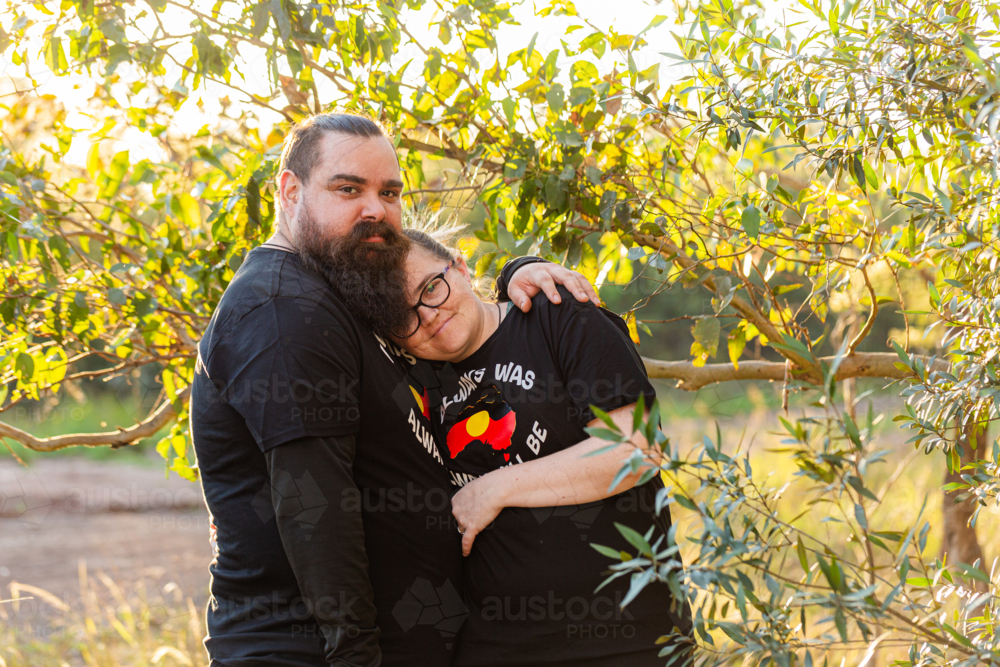 Image of Happy aboriginal Worimi couple hug in bushland wearing always ...