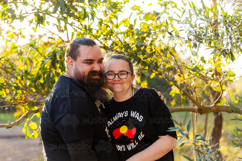 Image of Happy aboriginal Worimi couple hug in bushland wearing always ...