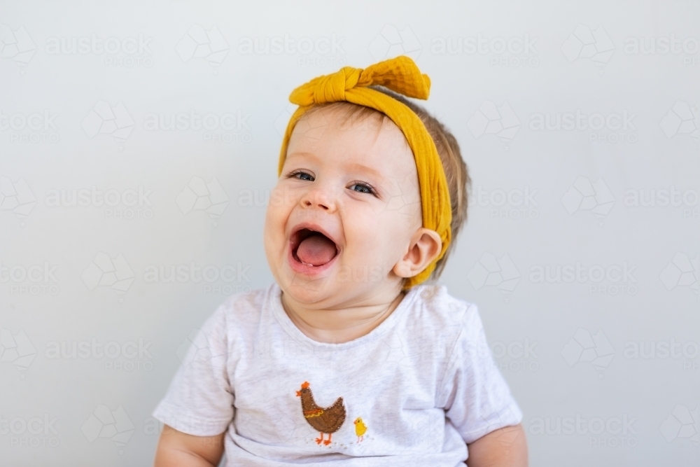 Image of happy aussie baby girl laughing with big smile on white copy ...