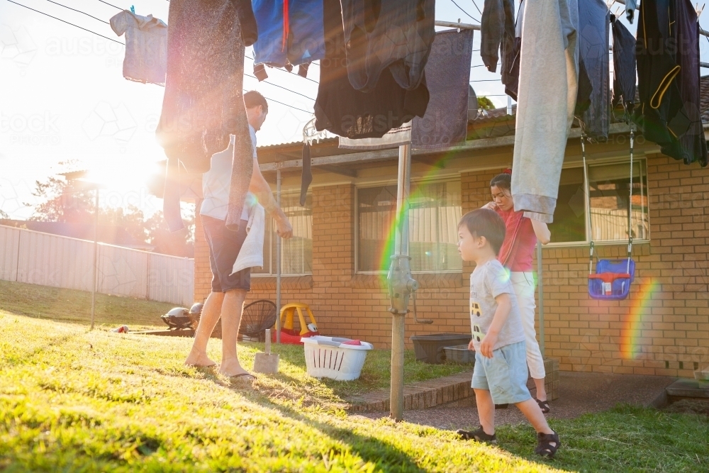 Image of Happy aussie toddler running under washing line in backyard ...